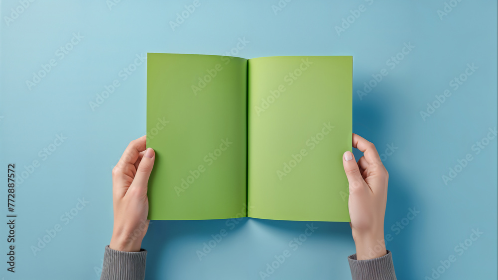 Hand holding blank brochure booklet or book mockup on blue background ...