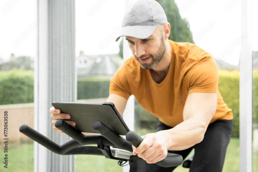 Spanish man with a stubble wearing a grey cap and orange top exercising ...