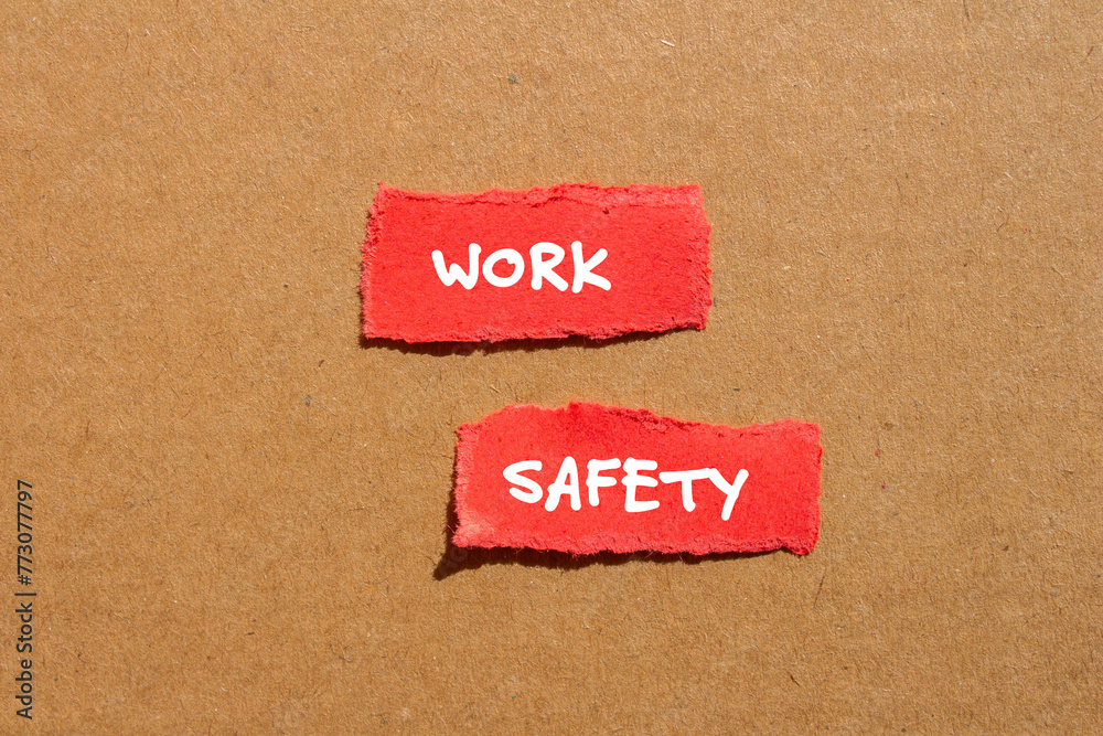 Work safety words written on red torn paper pieces with cardboard ...