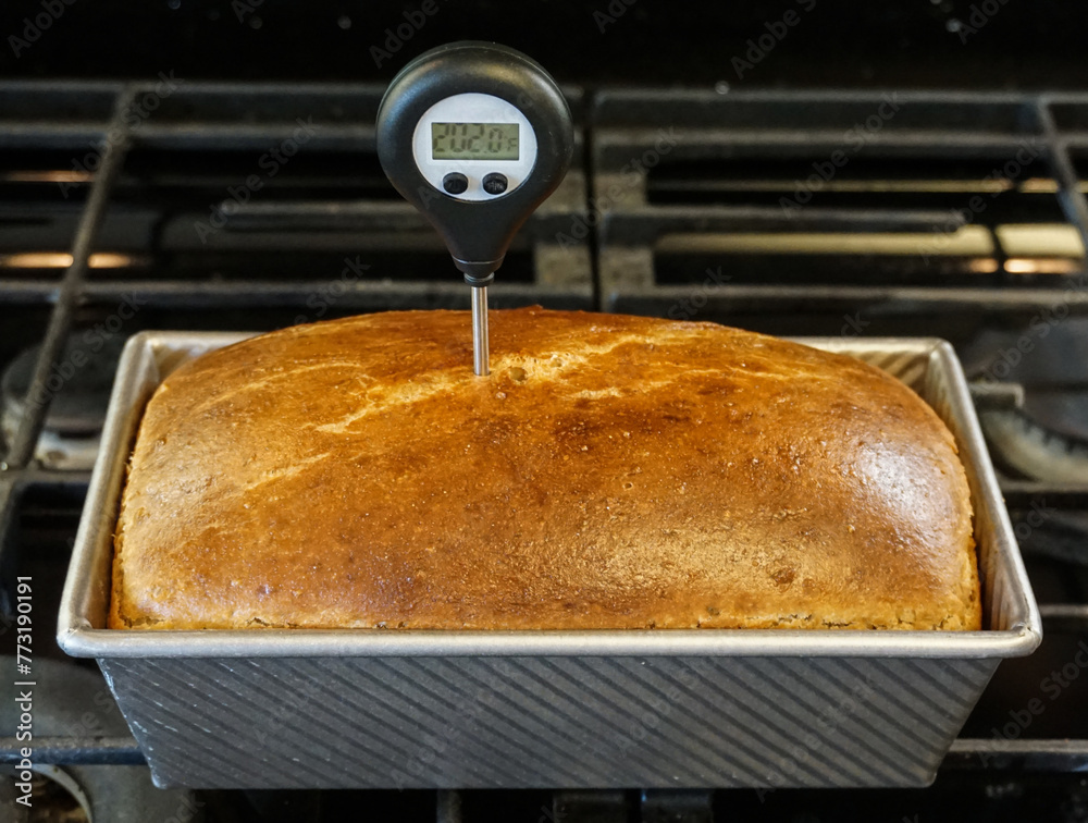 A bread thermometer, an essential baking tool, indicates the interior ...
