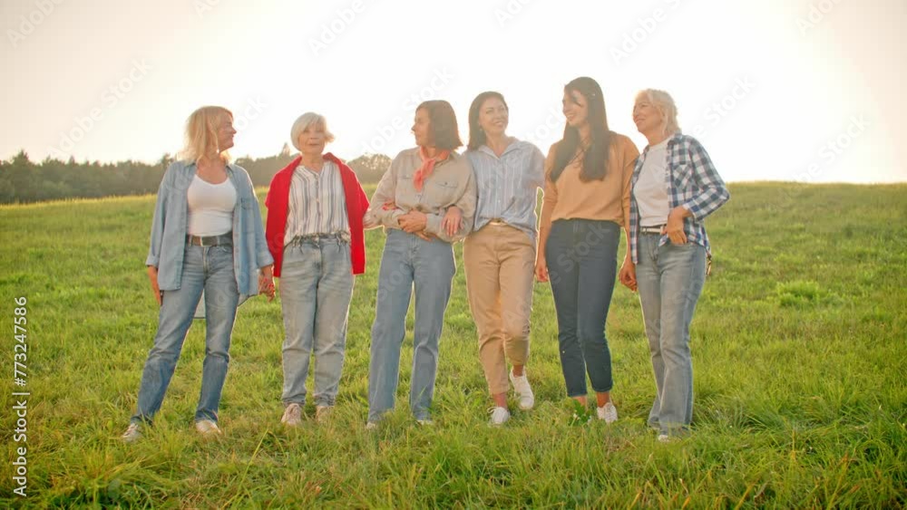 Camera view of group of differently aged women which hold each other ...