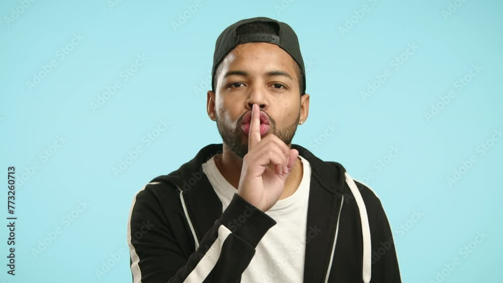 A pensive young man with braces on his teeth and wearing a baseball cap ...