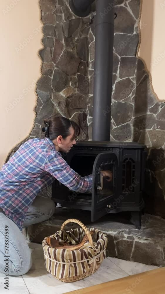 A young woman cleans the fireplace in her home, ensuring a tidy and ...