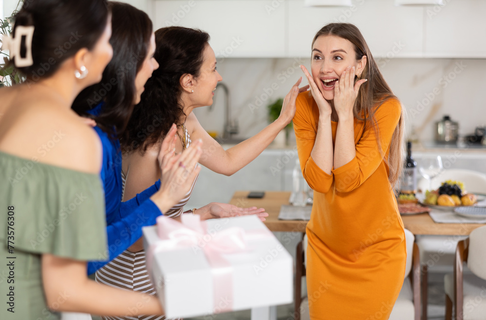Delighted surprised young woman in vibrant orange dress receiving ...