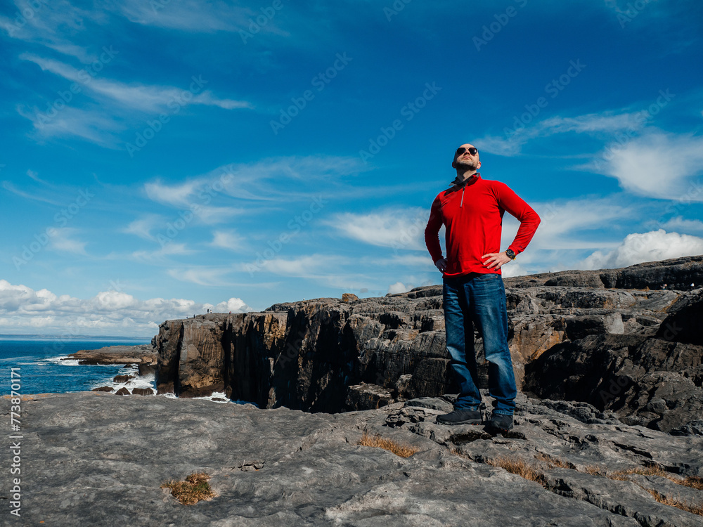Tourist standing and enjoy view of stunning mini cliff in county Clare ...
