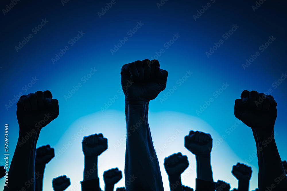 Silhouettes of male fists raised in the air, symbolizing the labor ...