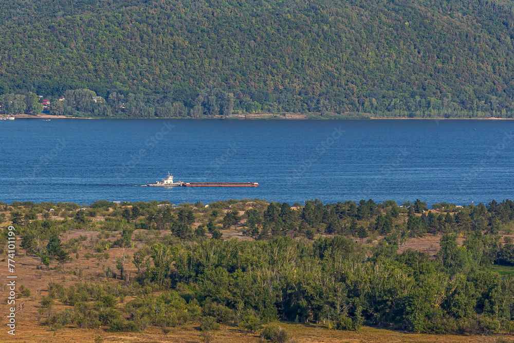 A tug pulls a barge along the Volga River near the city of Samara ...