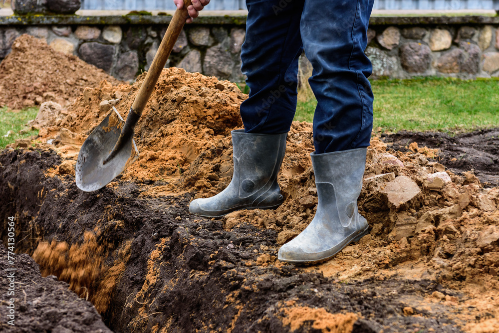 Earthworks, man digging trench using shovel. Stock Photo | Adobe Stock