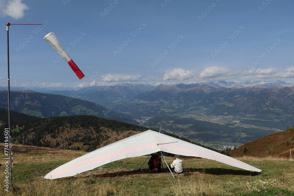 hang glider pilot and his coach sitting underneath the triangle control ...