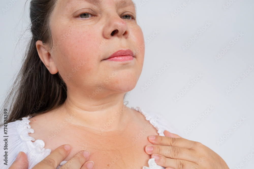 Woman 50 years old touching hand to collar bones and décolletage ...