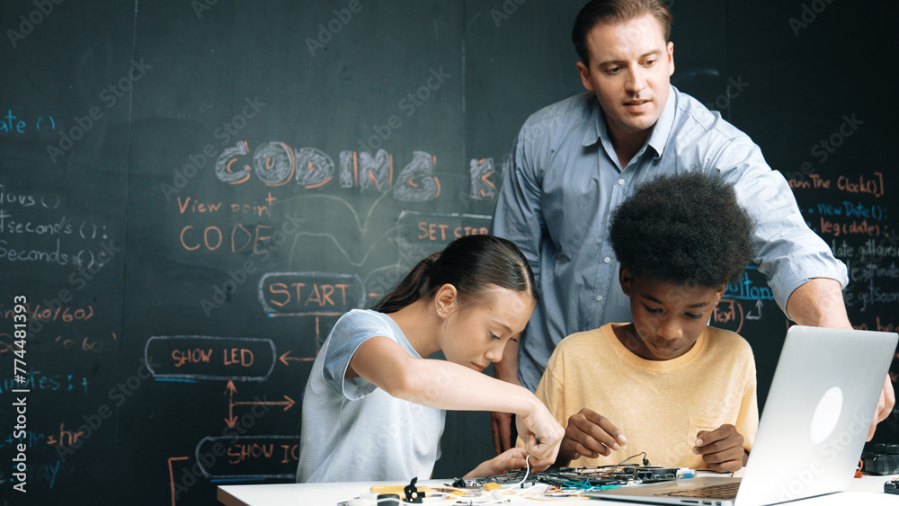 Caucasian teacher talking about electric tool while student fixing ...