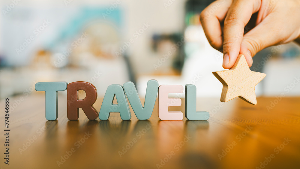 Businessman's hand is holding a star with the letters Travel, a concept ...