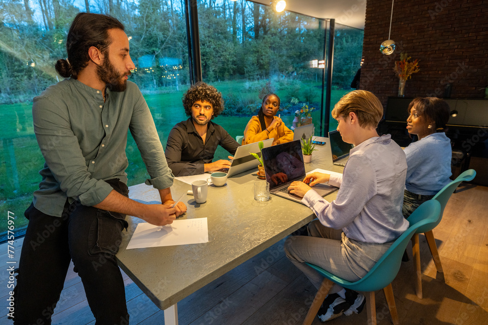 A diverse group of professionals convenes around a sleek table in a ...