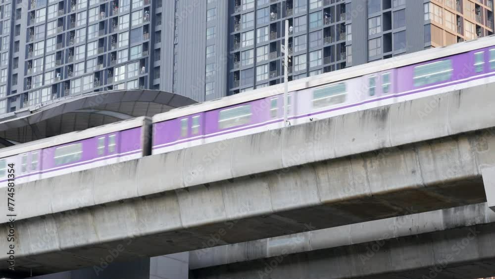 Purple train moving from right to left stopping by a station with high ...
