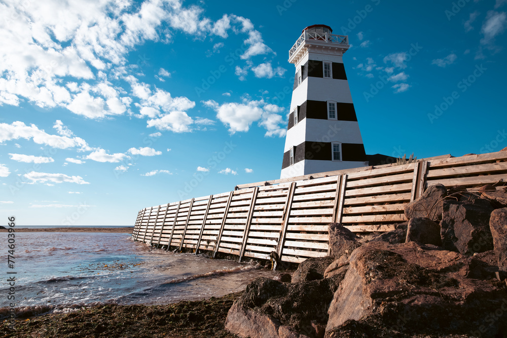 vue en bas angle sur un phare ligné noir et blanc en bord de mer avec ...
