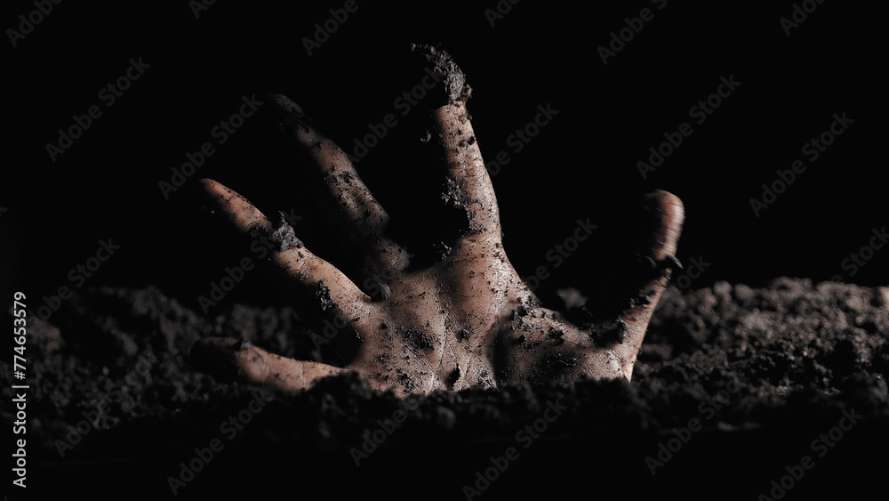 A human arm sticking eerily out of the ground, evoking the classic ...