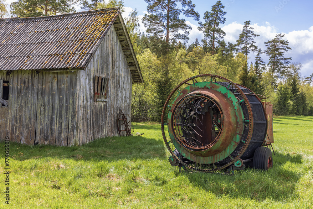 Old potato picker machine by a wooden barn in the countryside Stock ...