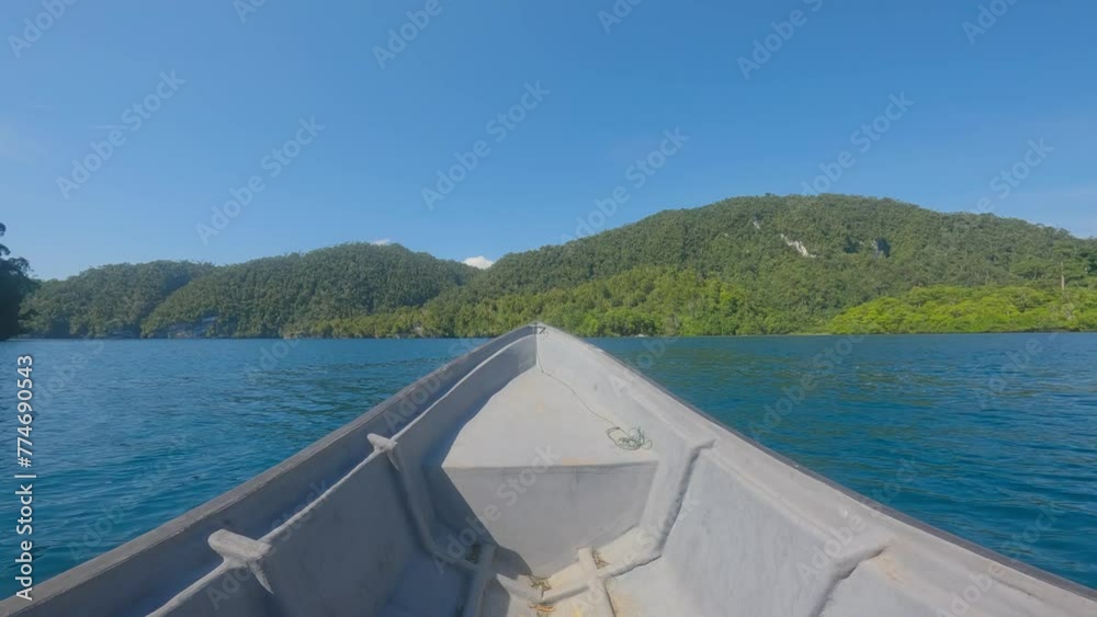 Bow of boat sailing toward island on Kali Biru blue river of Raja Ampat ...