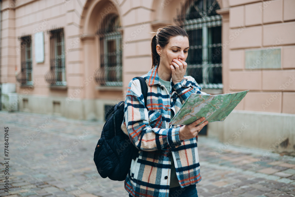 Portrait beautiful woman with paper map on urban street. Young worried ...