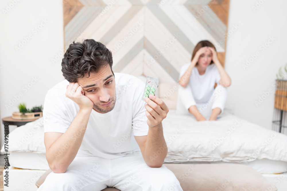 Frustrated and depressed man sitting on the edge of the bed after ...