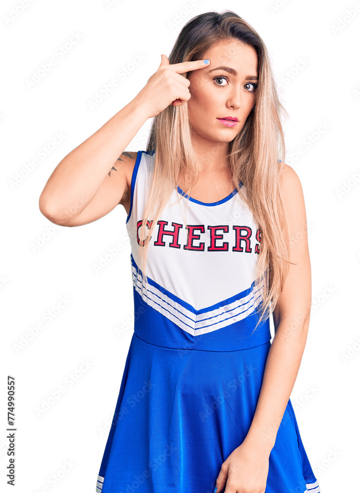Young beautiful blonde woman wearing cheerleader uniform pointing ...