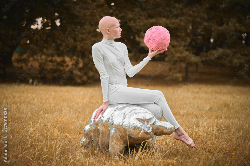 Young hairless girl with alopecia in white cloth sits on tardigrade ...