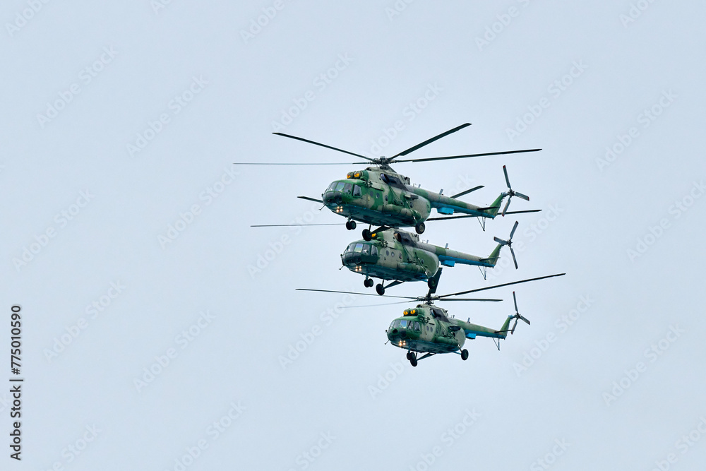 Three Russian military helicopters armed with missiles flies in blue ...