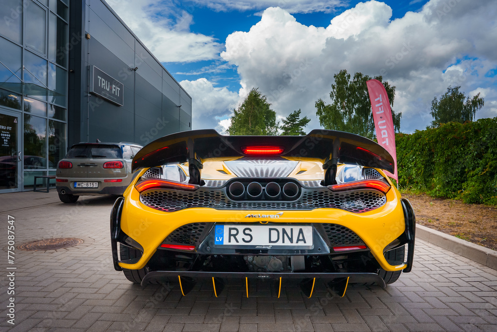 A vibrant yellow McLaren 765LT with an open rear engine cover ...