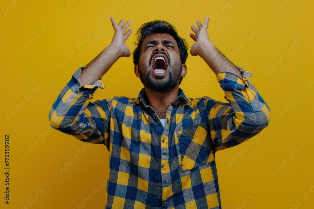 Shouting misunderstood stressed sad Indian man on yellow studio ...