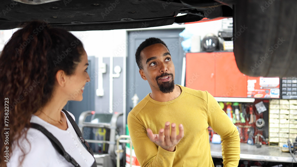 Mechanic is explaining to the customer about the breakdown of the car ...