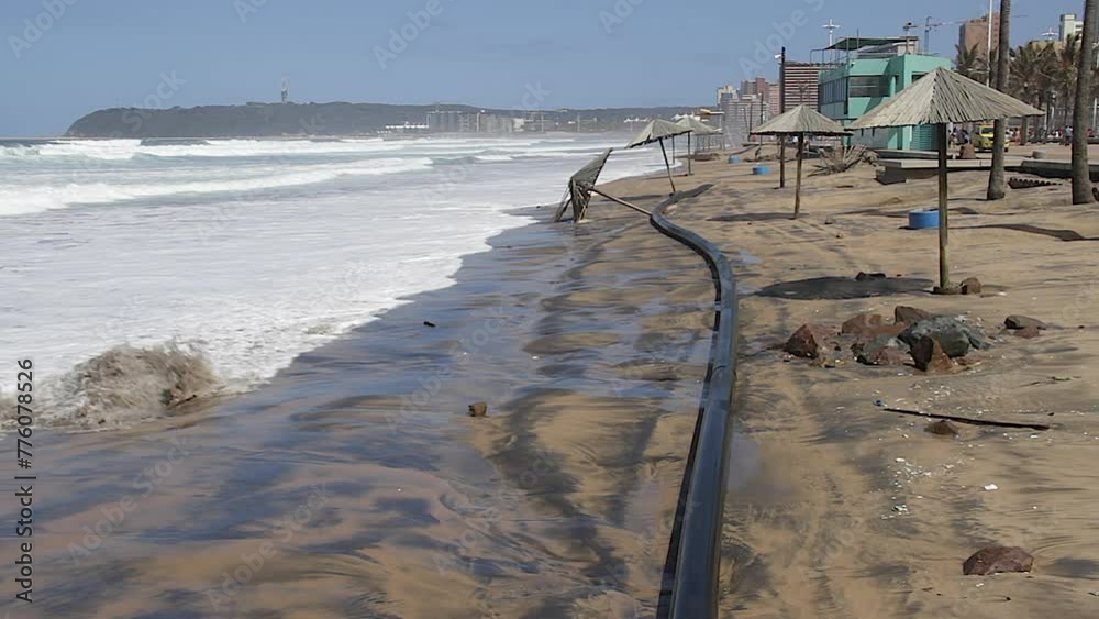 Climate Change Impact : An exposed pipe lying on the beach, with ...