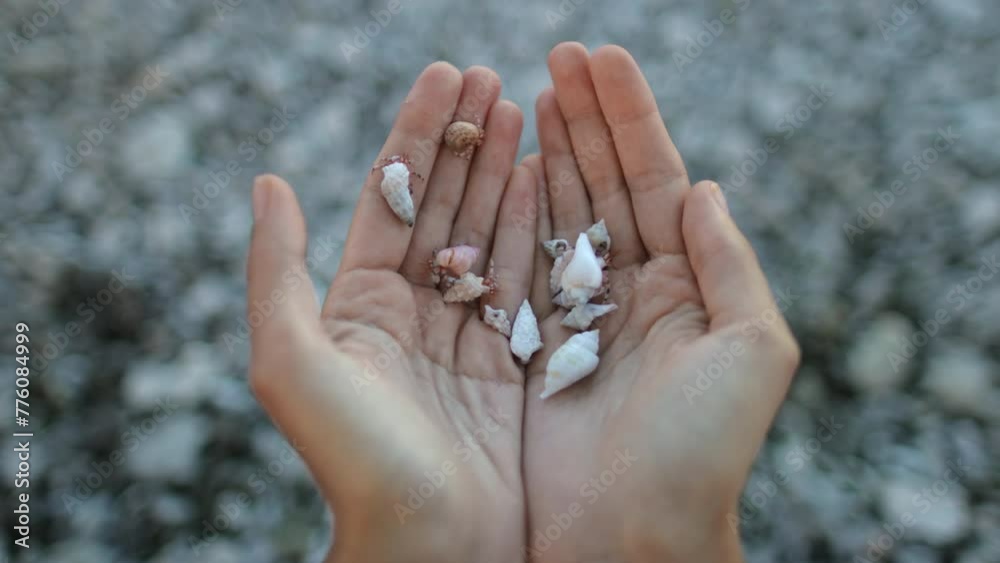 A person is shown with their hands held in front of them, adorned with ...