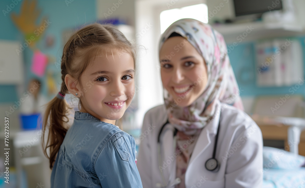 Young girl standing beside pediatrician wearing a hijab, smiling ...