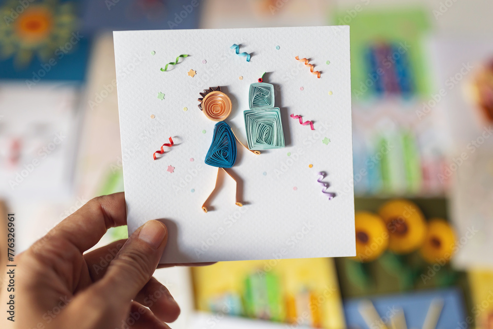 Hand holding quilling card with quilled stick figure man giving a cake ...
