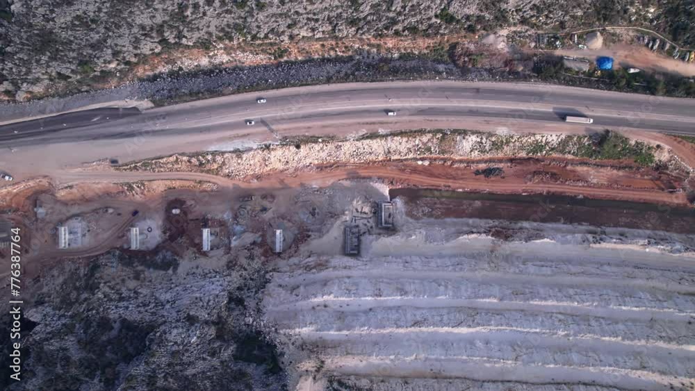Aerial view of highway ledges under construction after drilling and ...