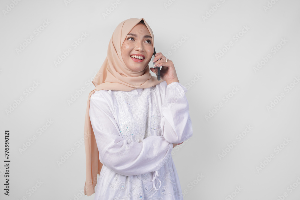 Happy Asian Muslim woman wearing white dress and hijab holding her ...