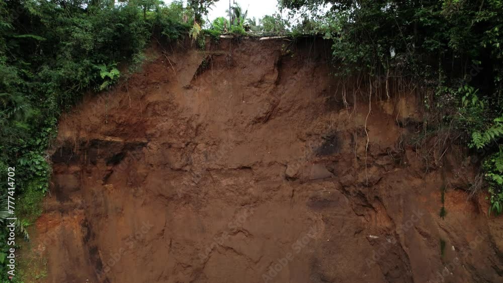 Top edge of recent landslide, exposed sandy earth, damaged road ...