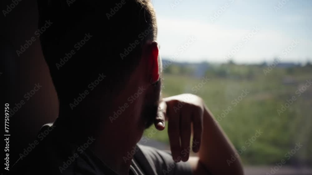 Young Caucasian man sitting riding inside a train, looking pensive and ...