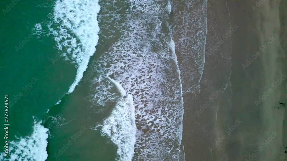 Waves crashing down on a beach (Portrush West Strand). Camera begins ...
