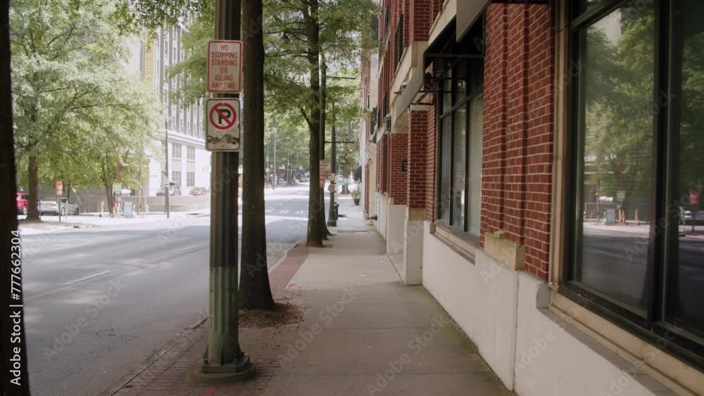 Sidewalk with road signs on metal pole, between road and building with ...