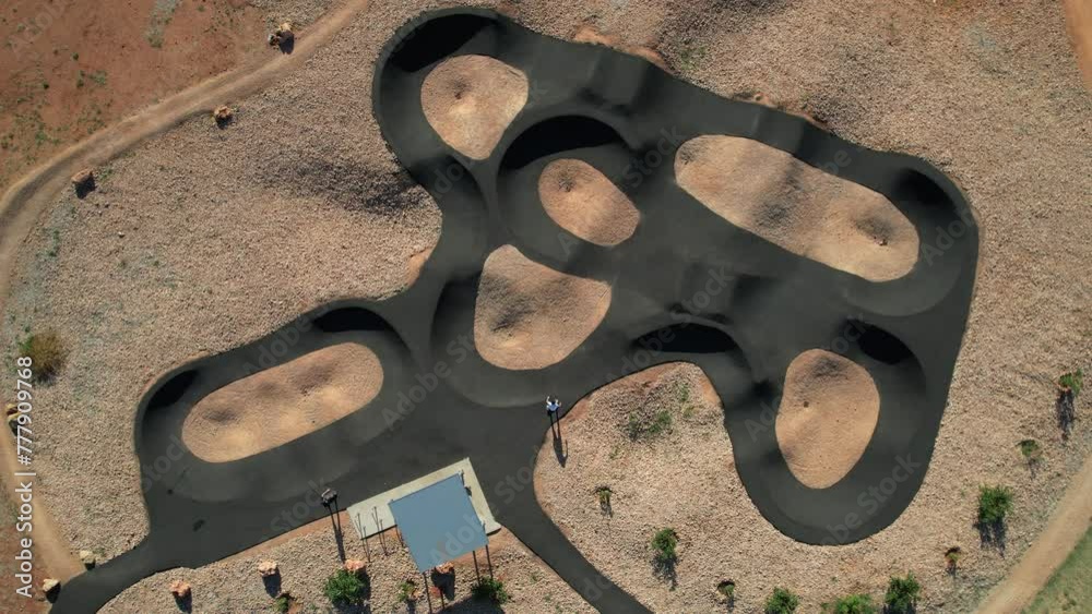 Aerial video of two boys playing at the skatepark. Friends doing loops around the pump track ...