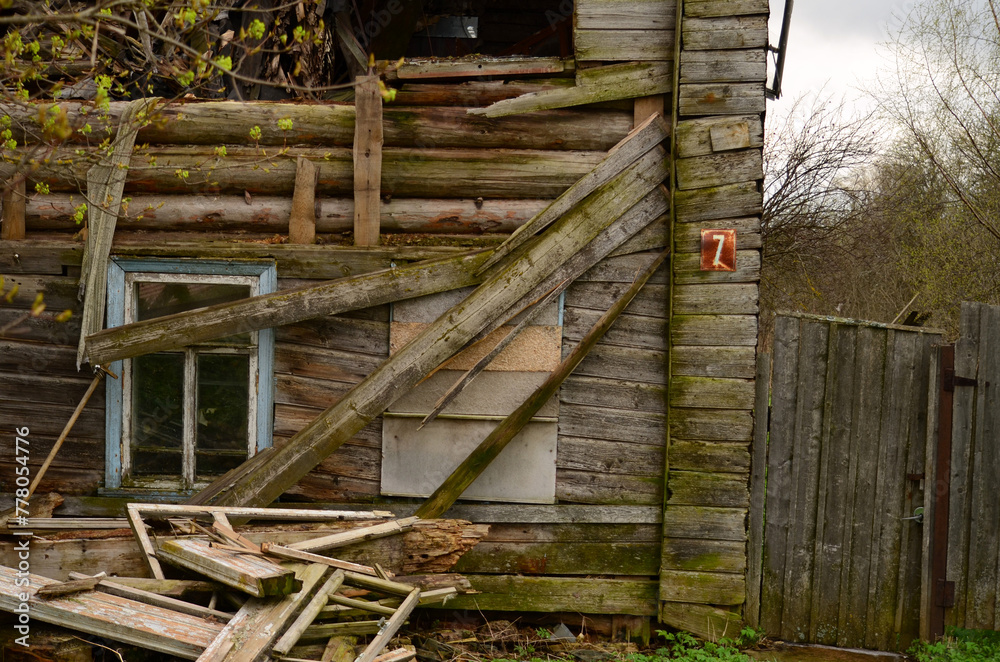 Fragment of a destroyed old wooden house. The logs of the wall have ...
