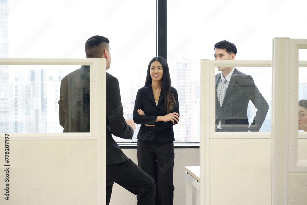 Smiling businessman and beautiful female employee stand talking in the ...