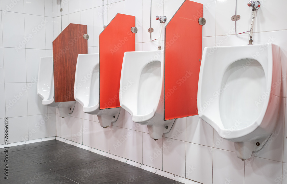 Side view of a white-walled public restroom with four symmetrical ...