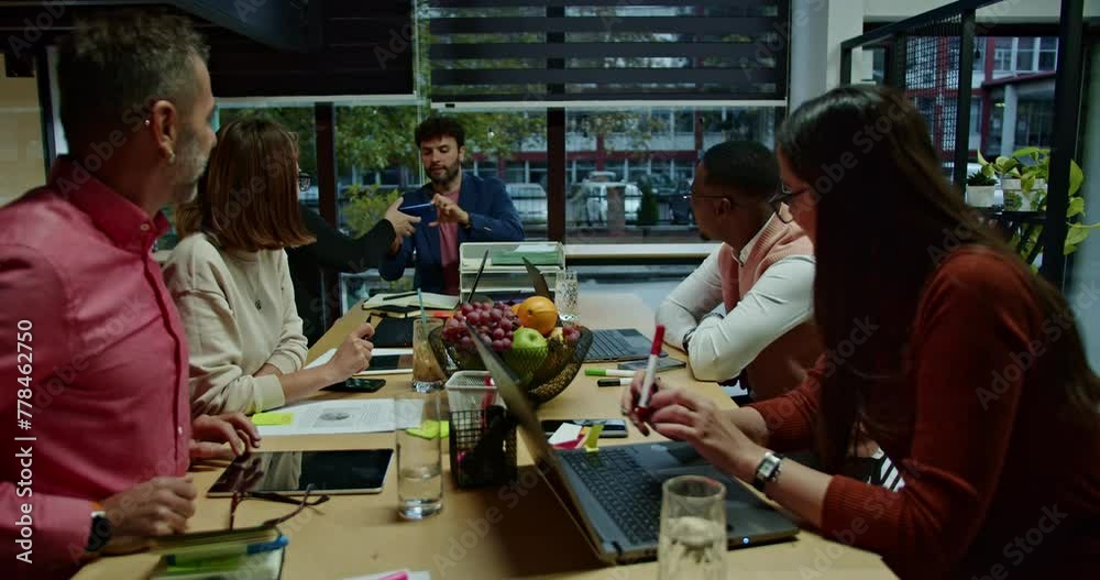 Using a smart phone, a mix of colleagues of different ages gather for a ...