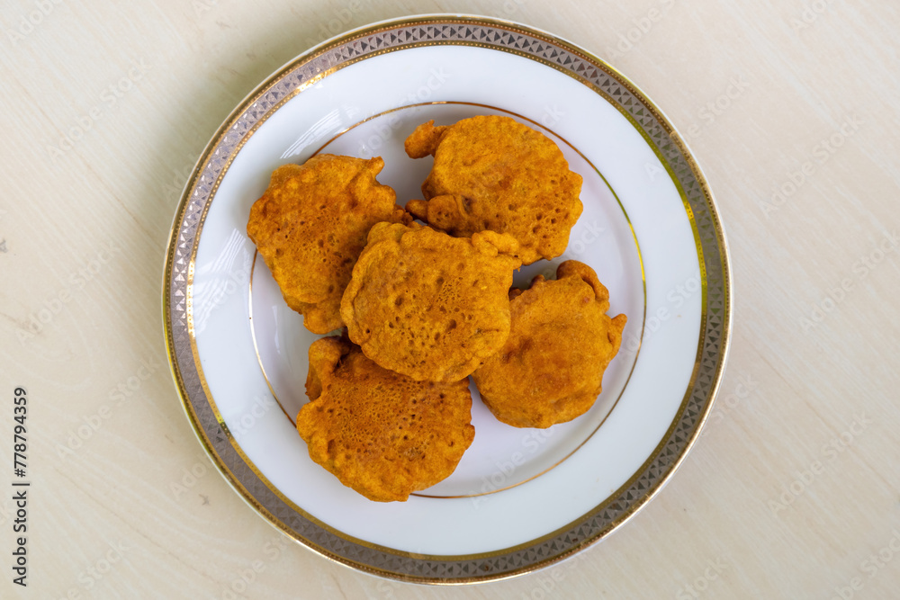 Delicious homemade Aloo Chop on a white plate on wooden background. Alu ...