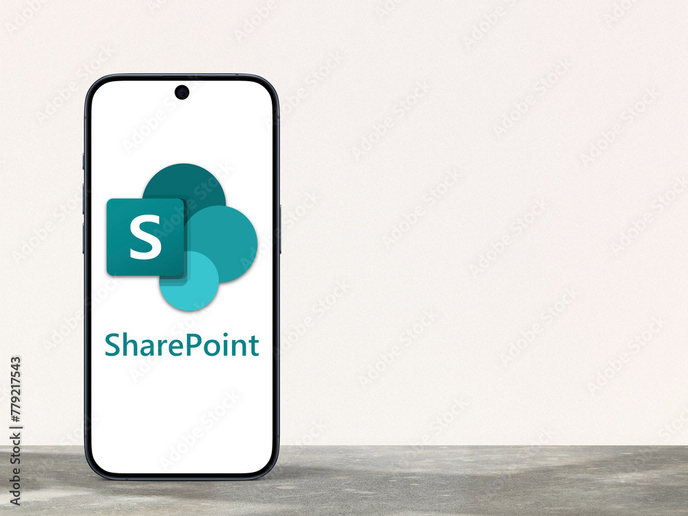 Microsoft Sharepoint logo is displayed on a smartphone standing on a ...