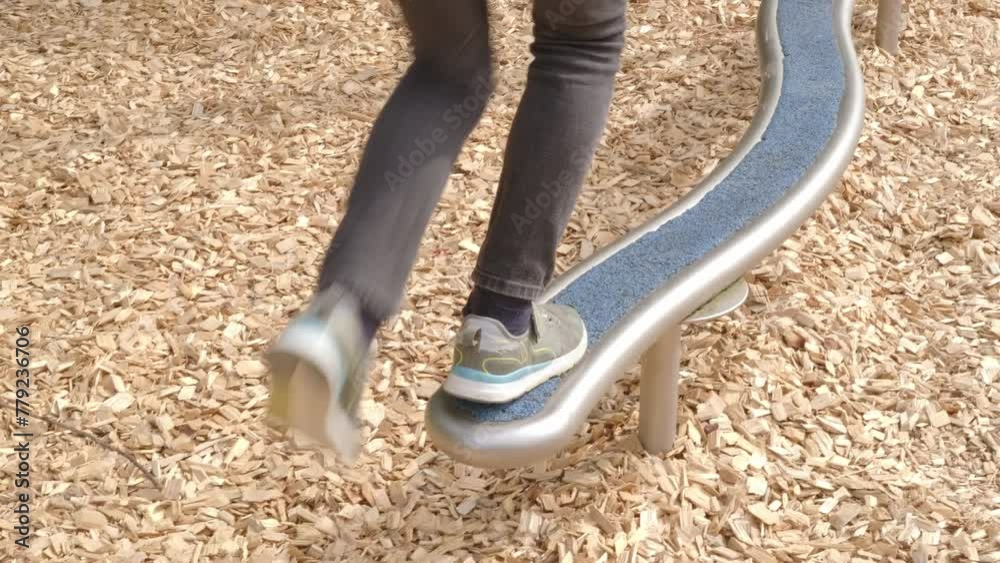 Young child walking, balancing on sports equipment at playground ...