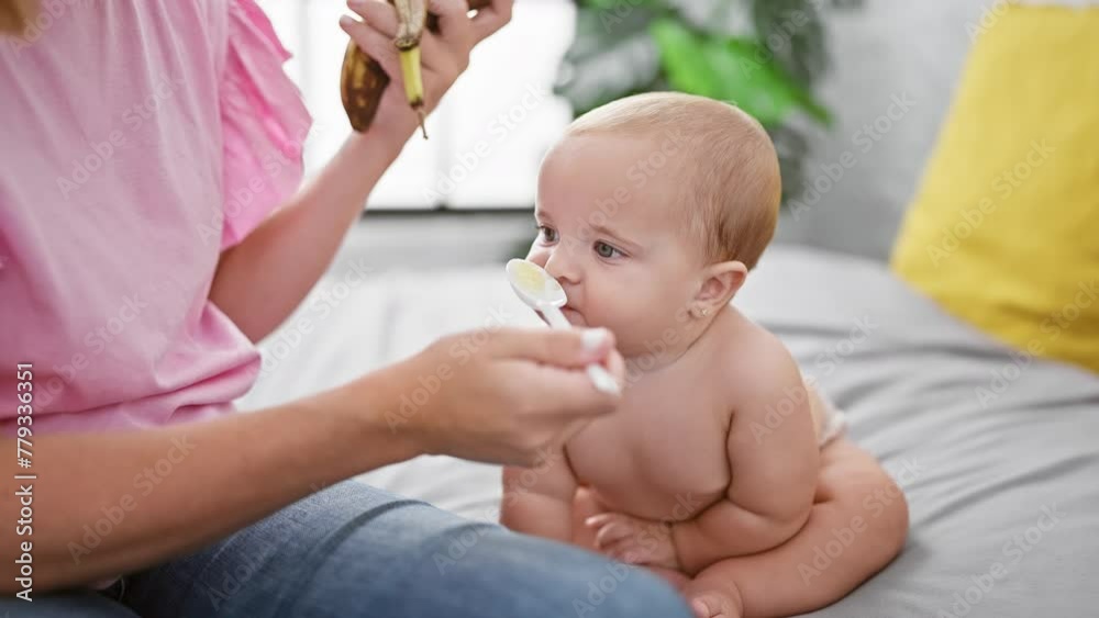 Loving mother sitting on bed, sharing a healthy banana snack with her ...