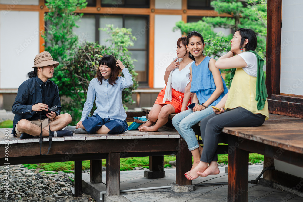 Group of five Japanese friends casually enjoying a conversation on a ...
